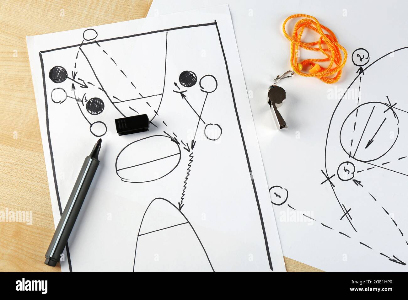 Scheme basketball game on sheet of paper and wooden table background ...