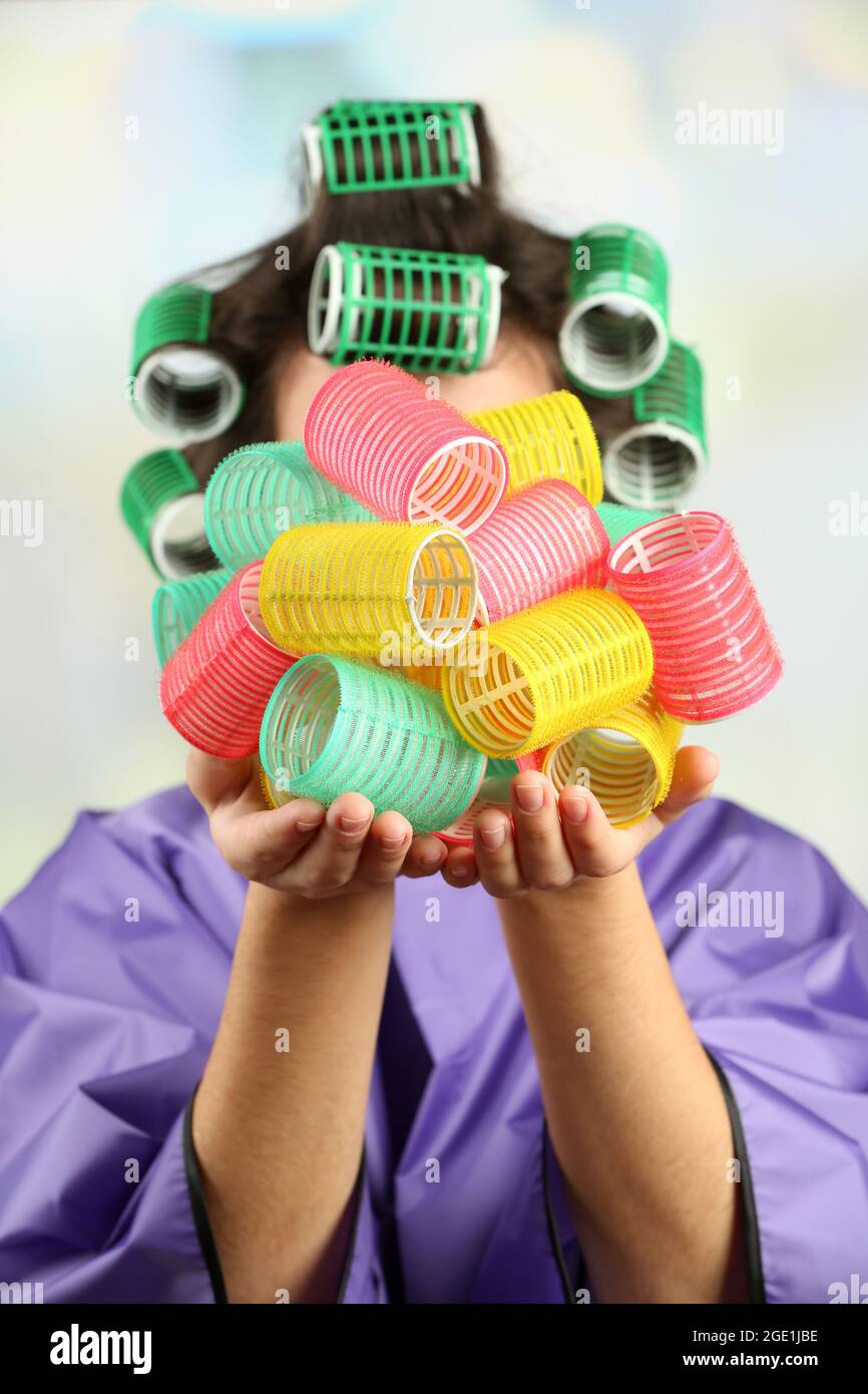 Girl in hair curlers on bright background Stock Photo - Alamy