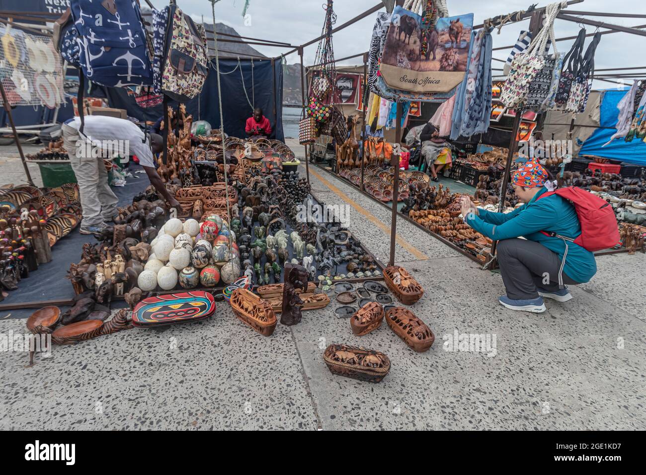 A tourist browsing for African curios and crafts at a street stall in ...