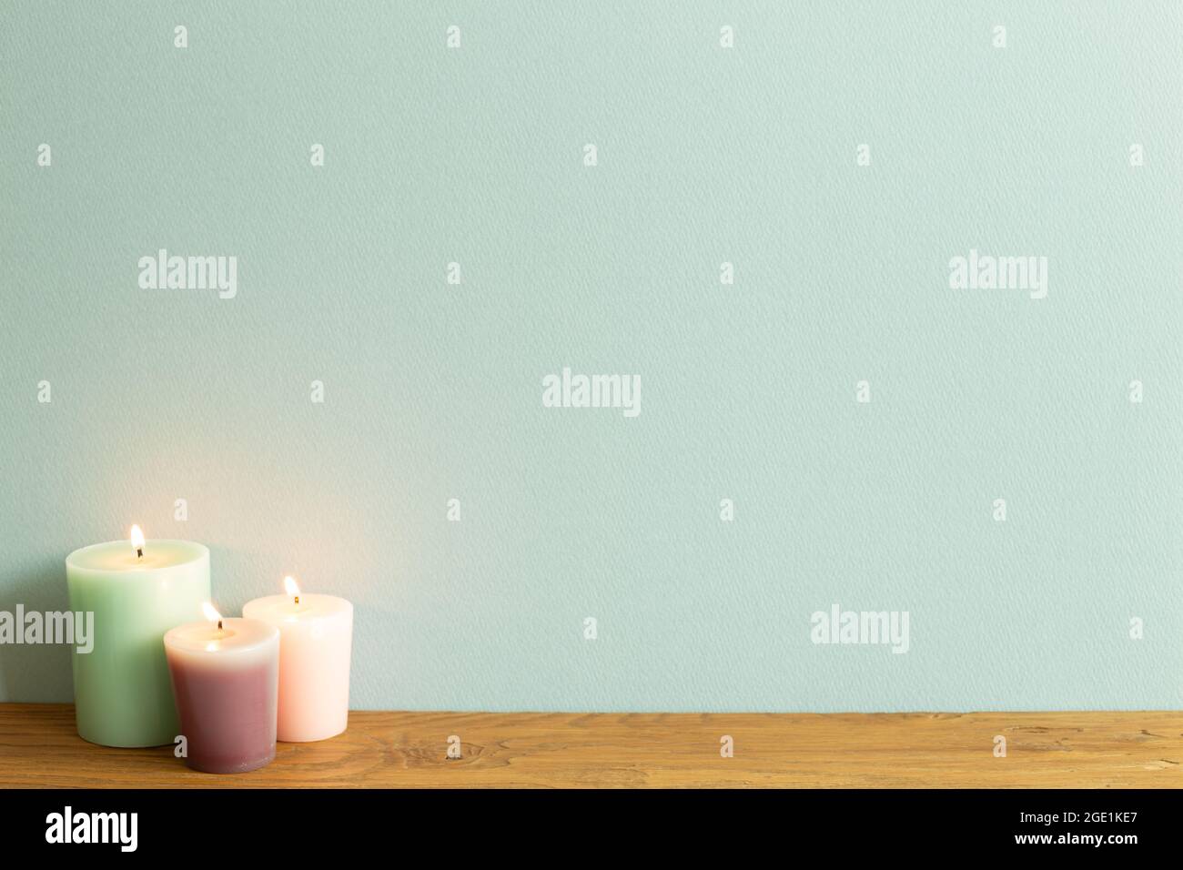 Color candles on wooden table. blue wall background. home interior ...