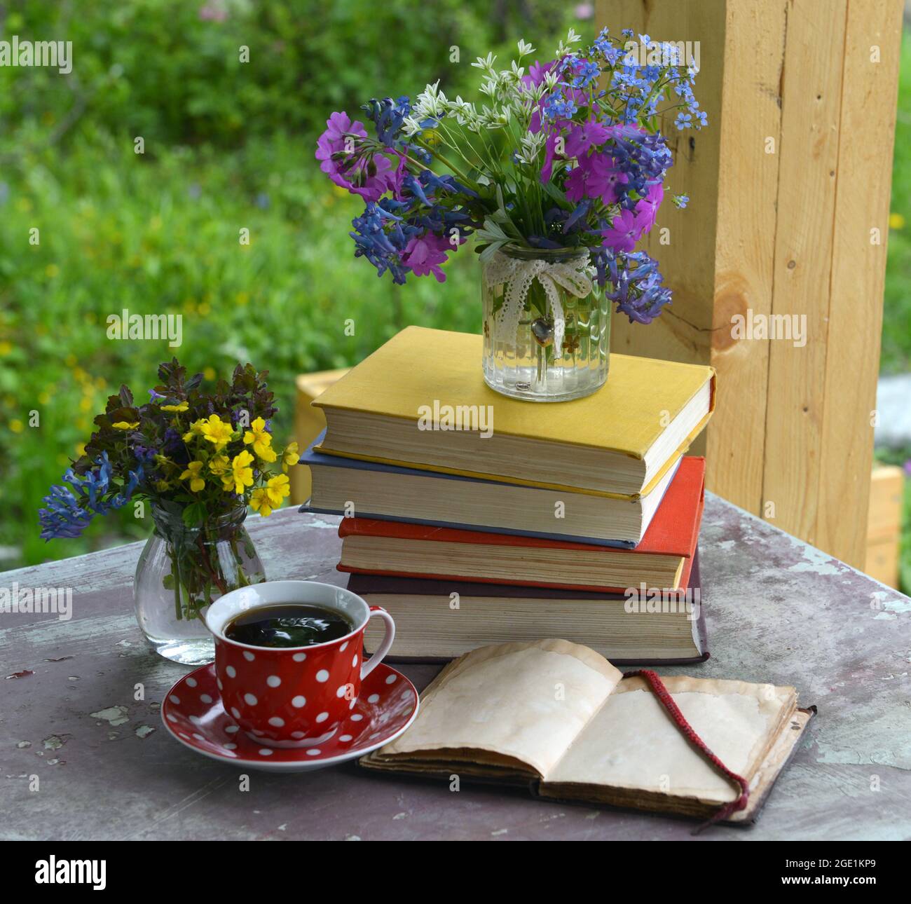 Still life with open diary, cup of tea and pile of books on the porch ...