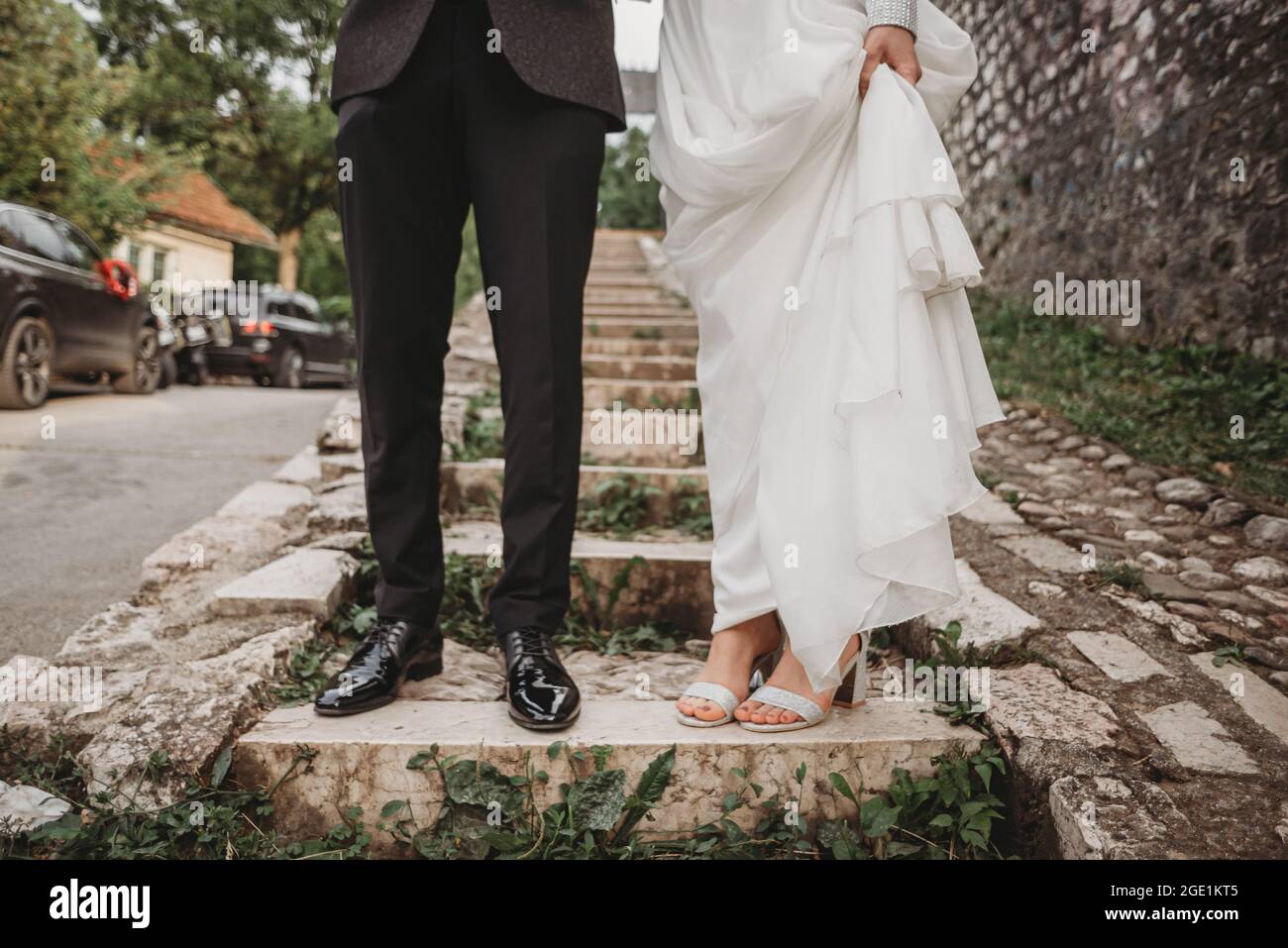 bride and groom legs wedding shoes, dress and suit Stock Photo - Alamy
