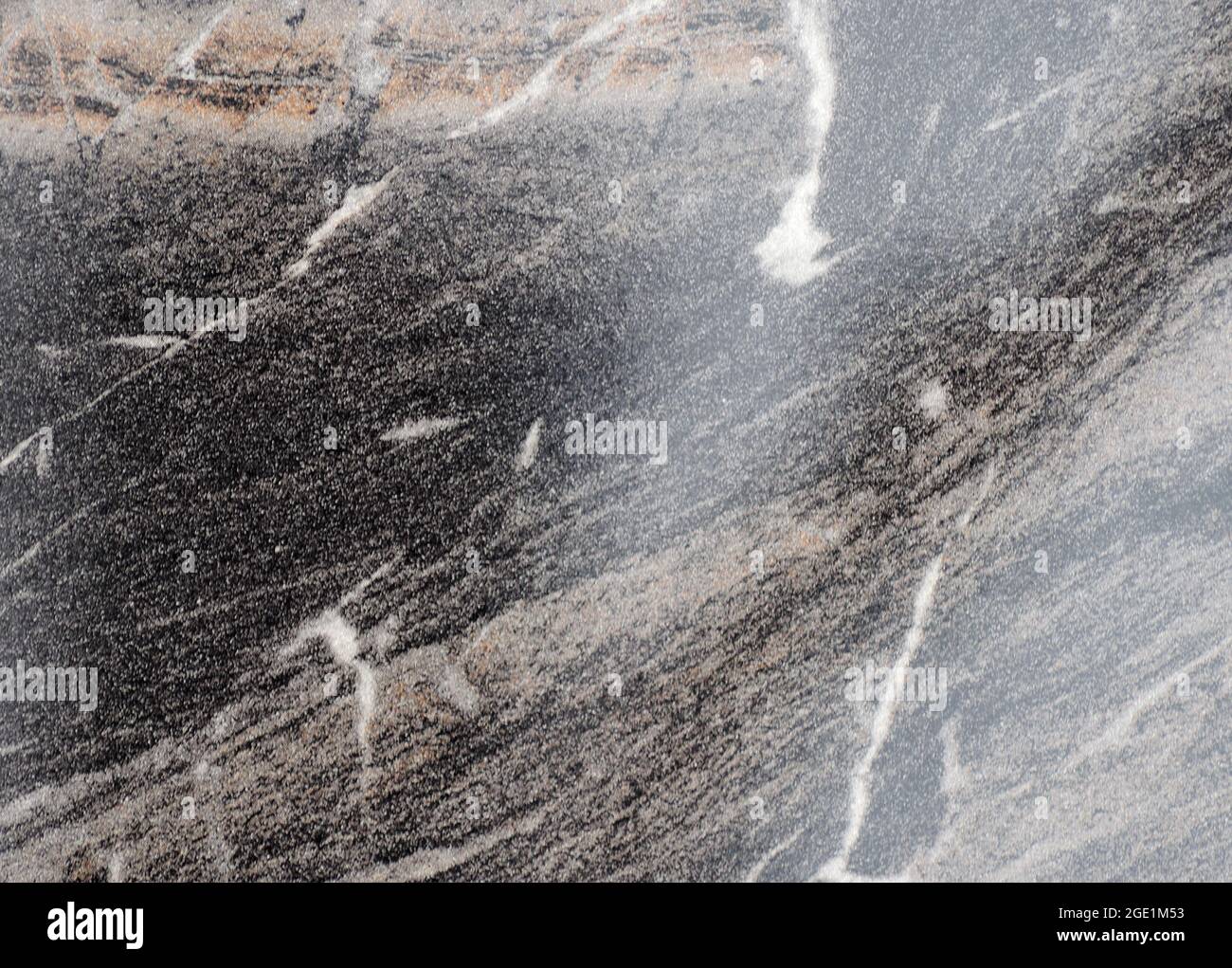 Black marble, polished shiny surface of natural stone with large brown ...