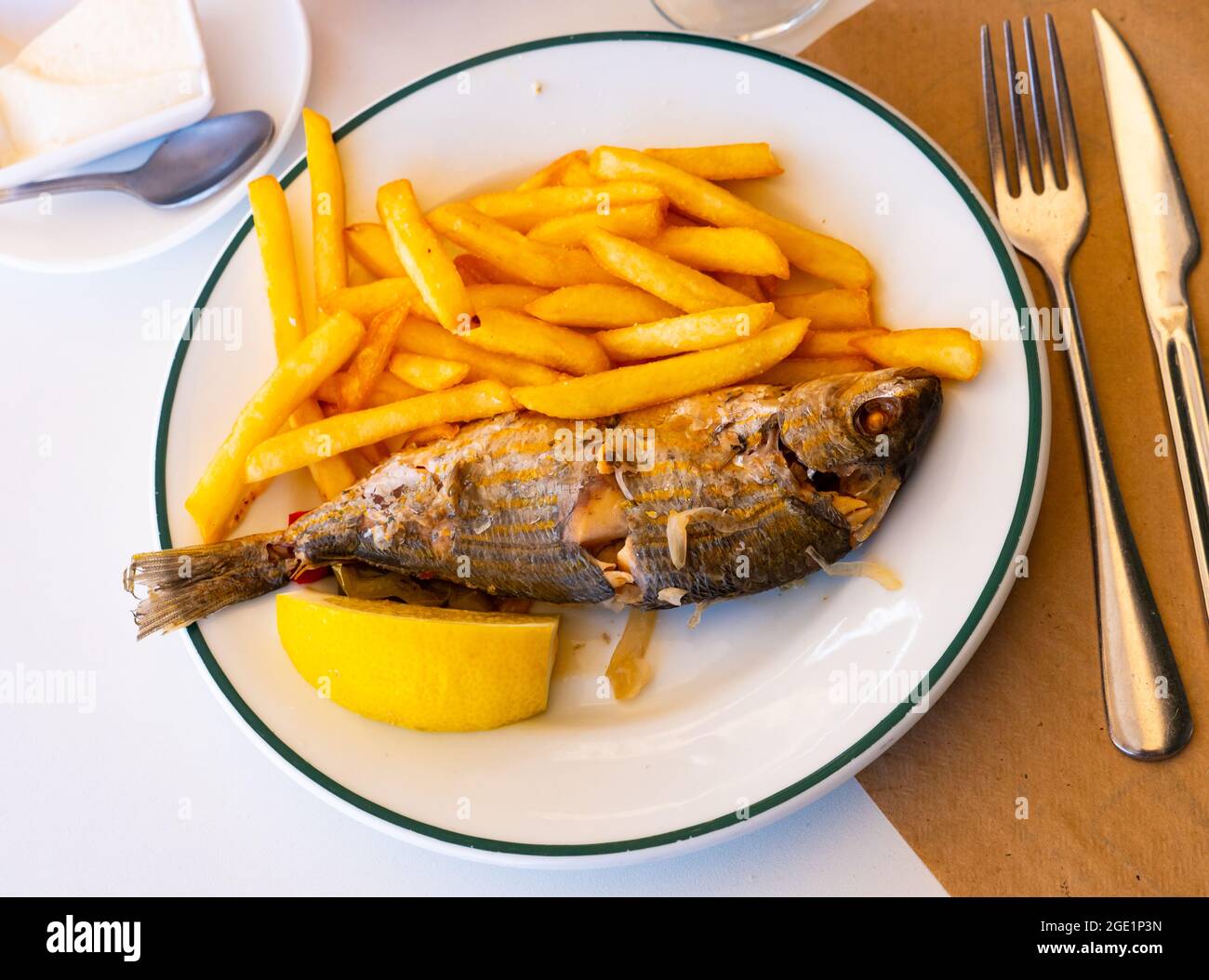 Fried sarpa salpa served with lemon and crispy fries Stock Photo - Alamy