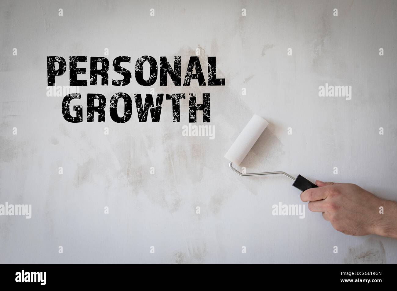 Personal Growth concept. Man with a roller of paint and white wall ...