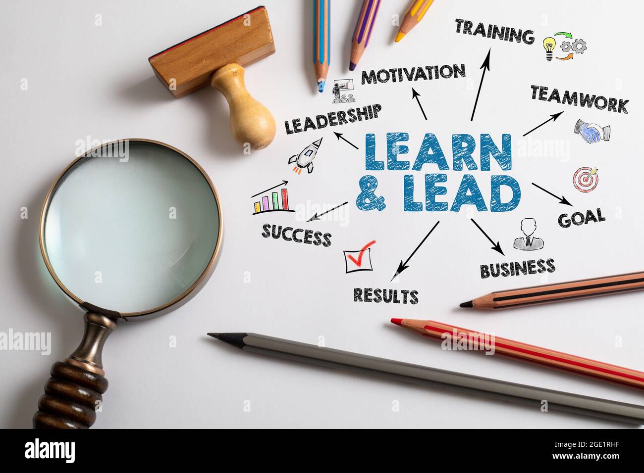 Learn and Lead concept. Pencils and magnifying glass on a white ...