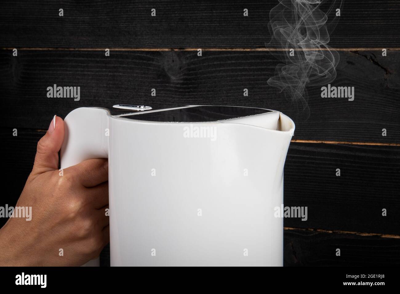 Hot water kettle in a woman's hand Stock Photo - Alamy