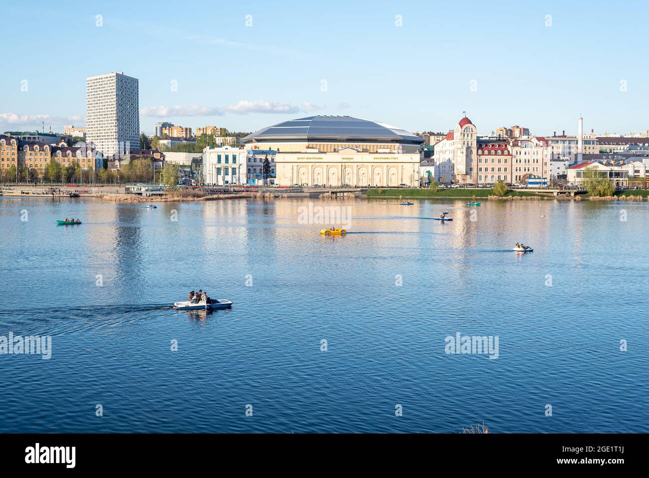 Numerous catamarans and boats sail along tranquil river against modern ...