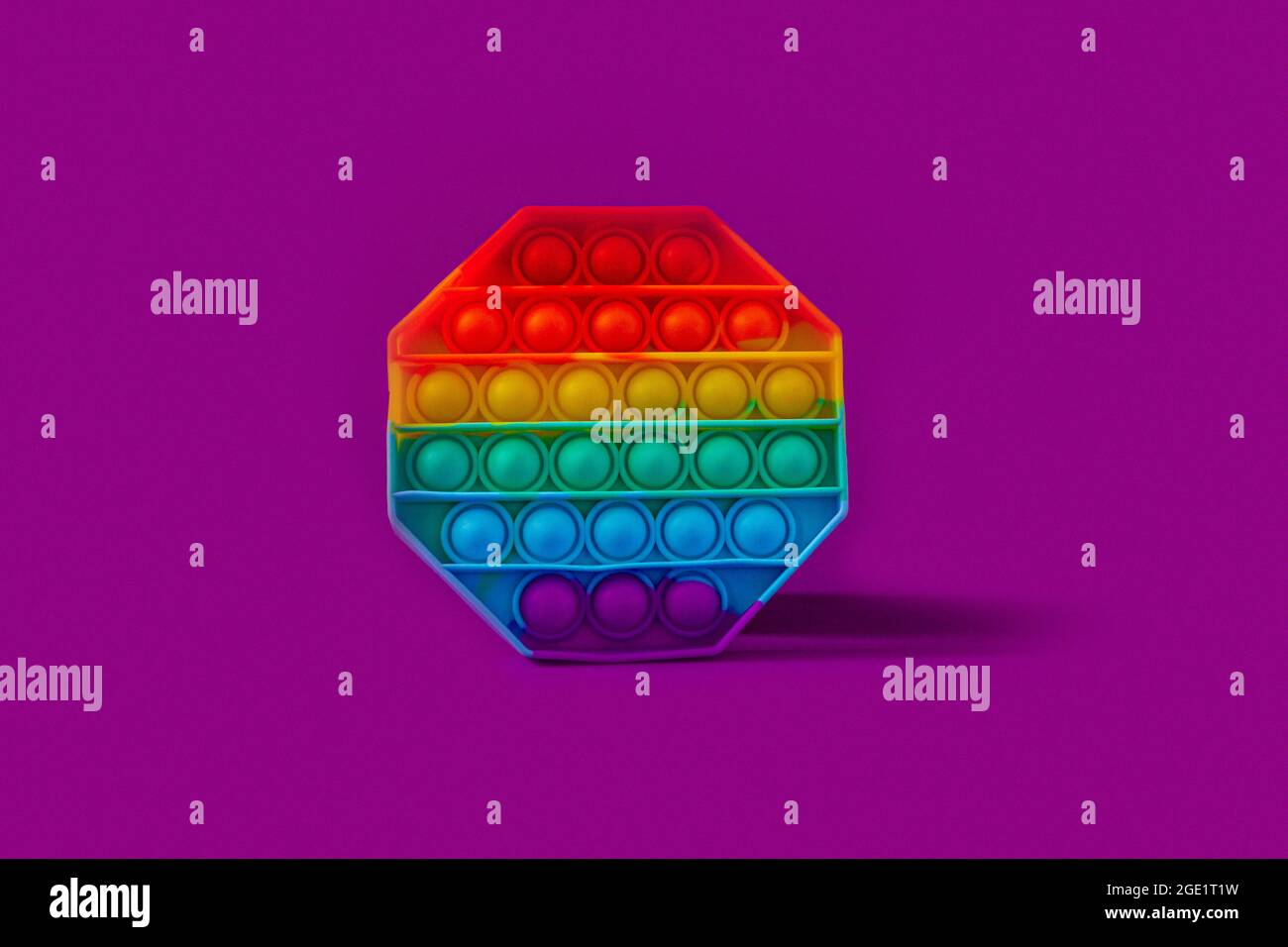 Silicone octagon toy fidget pop it on purple background Stock Photo - Alamy