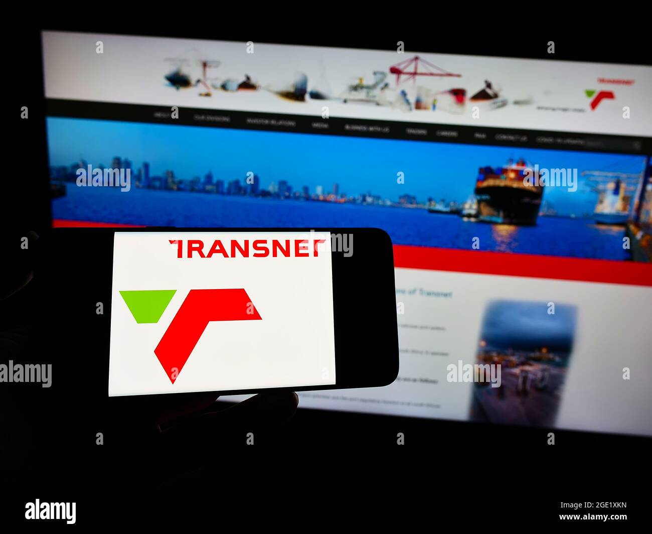 Person holding cellphone with logo of South African logistics company Transnet SOC Ltd. on ...