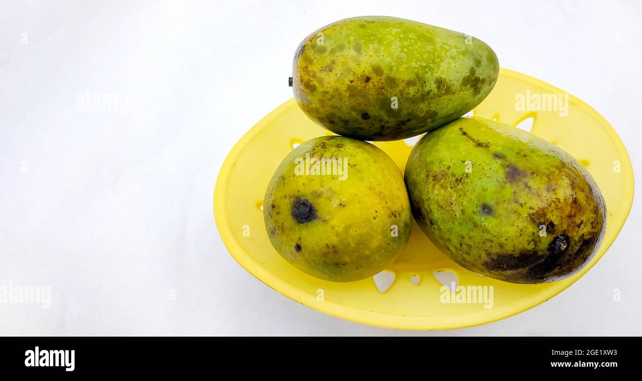 Three large ripe mangoes in a basket isolated on white background Stock ...