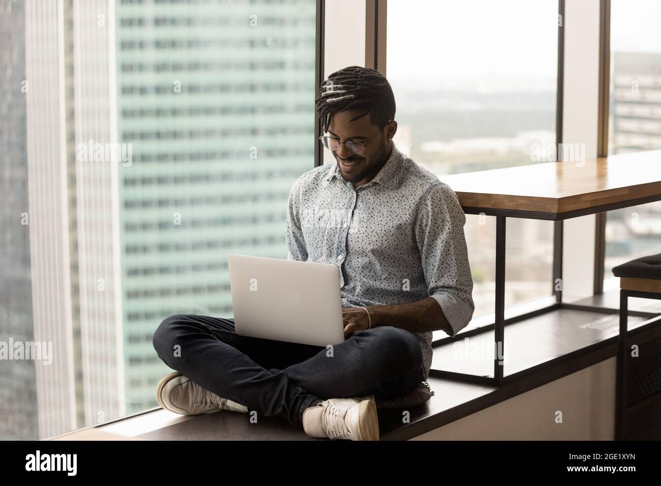 African guy working remotely sit cross-legged with laptop Stock Photo ...