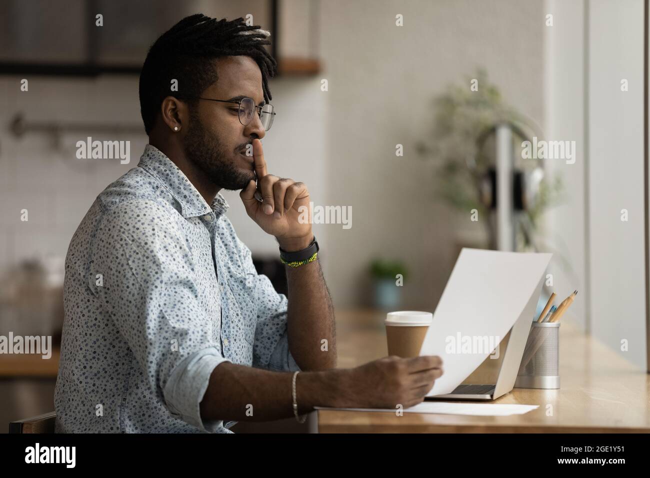 African guy reading paper hi-res stock photography and images - Alamy
