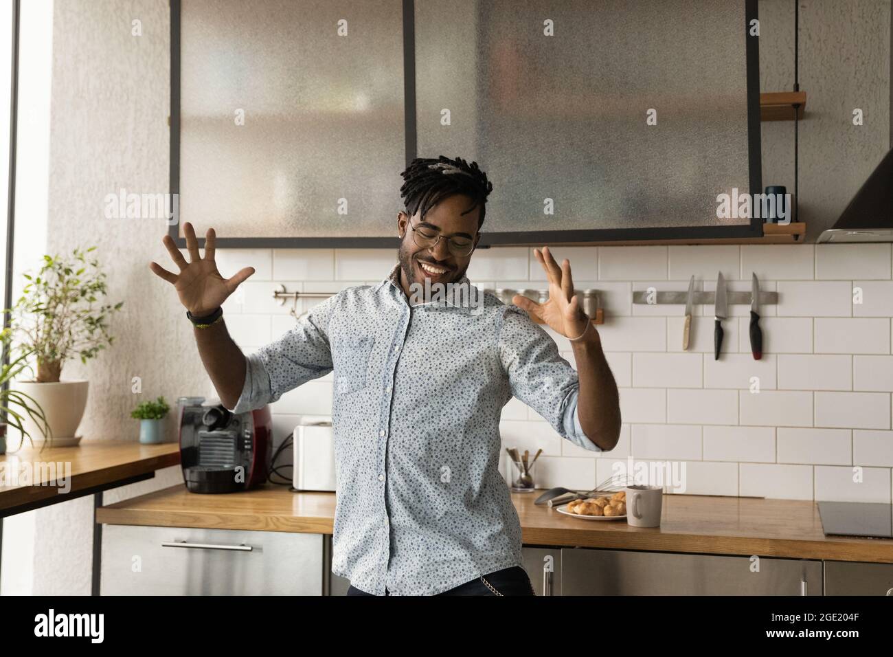 Carefree lively African guy dancing alone in domestic kitchen Stock ...
