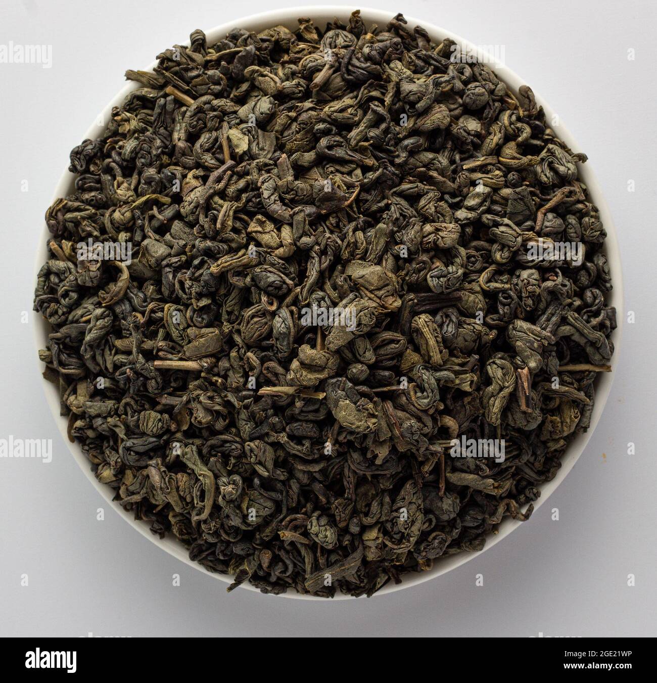 Dried Chinese Gunpowder green tea leaves in a bowl, on a white ...