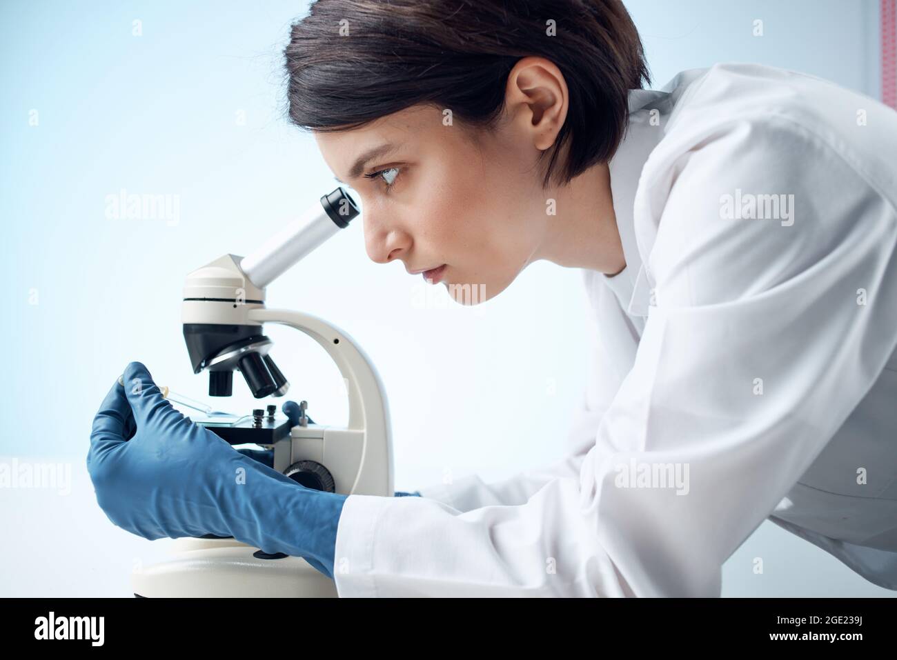 female laboratory assistant looking microscope diagnostics professional ...