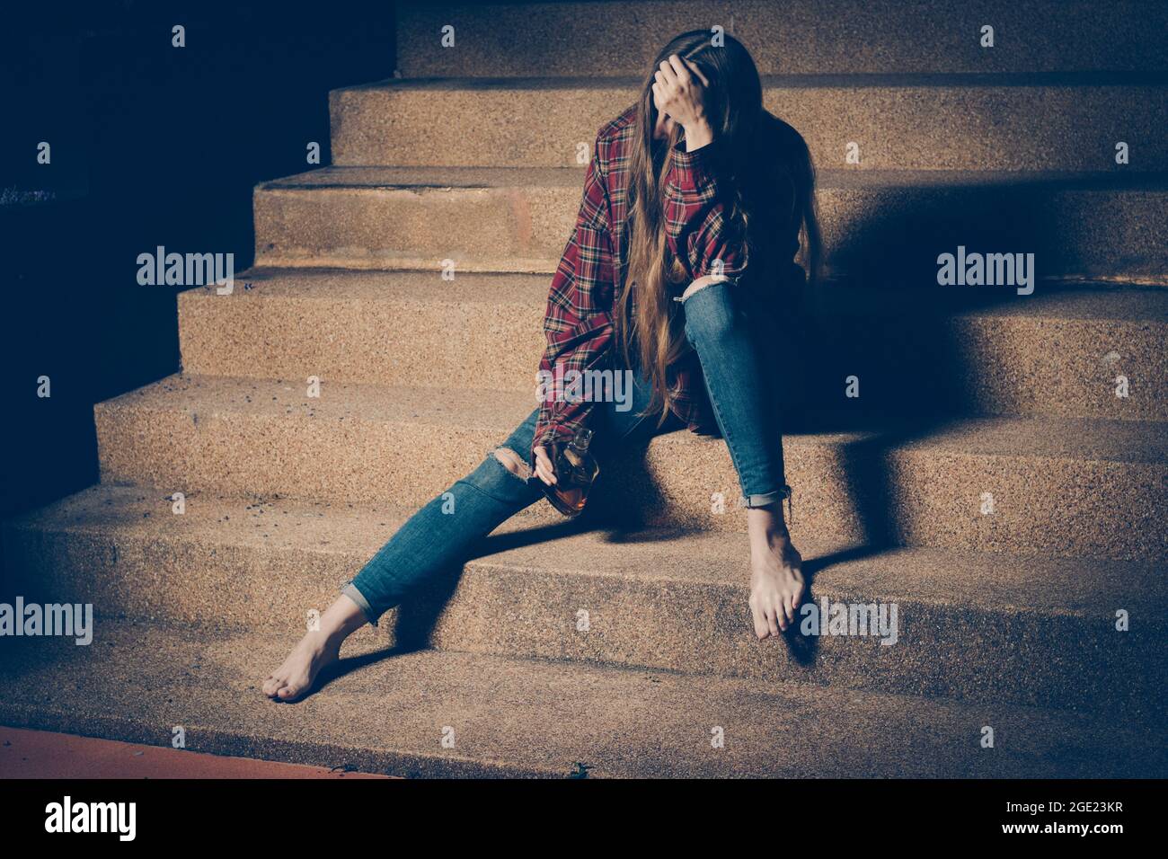 Young drunk woman sitting outside in night. Alcoholism and drug ...