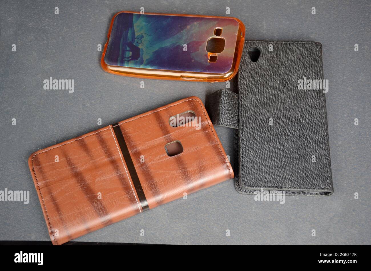 closeup the bunch black ,brown color phone flip cover with orange back ...