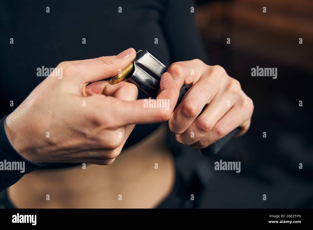 Experienced Caucasian female shooter loading a pistol Stock Photo - Alamy