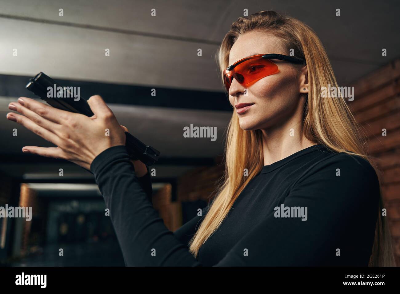 Serious concentrated beautiful lady reloading her handgun Stock Photo ...