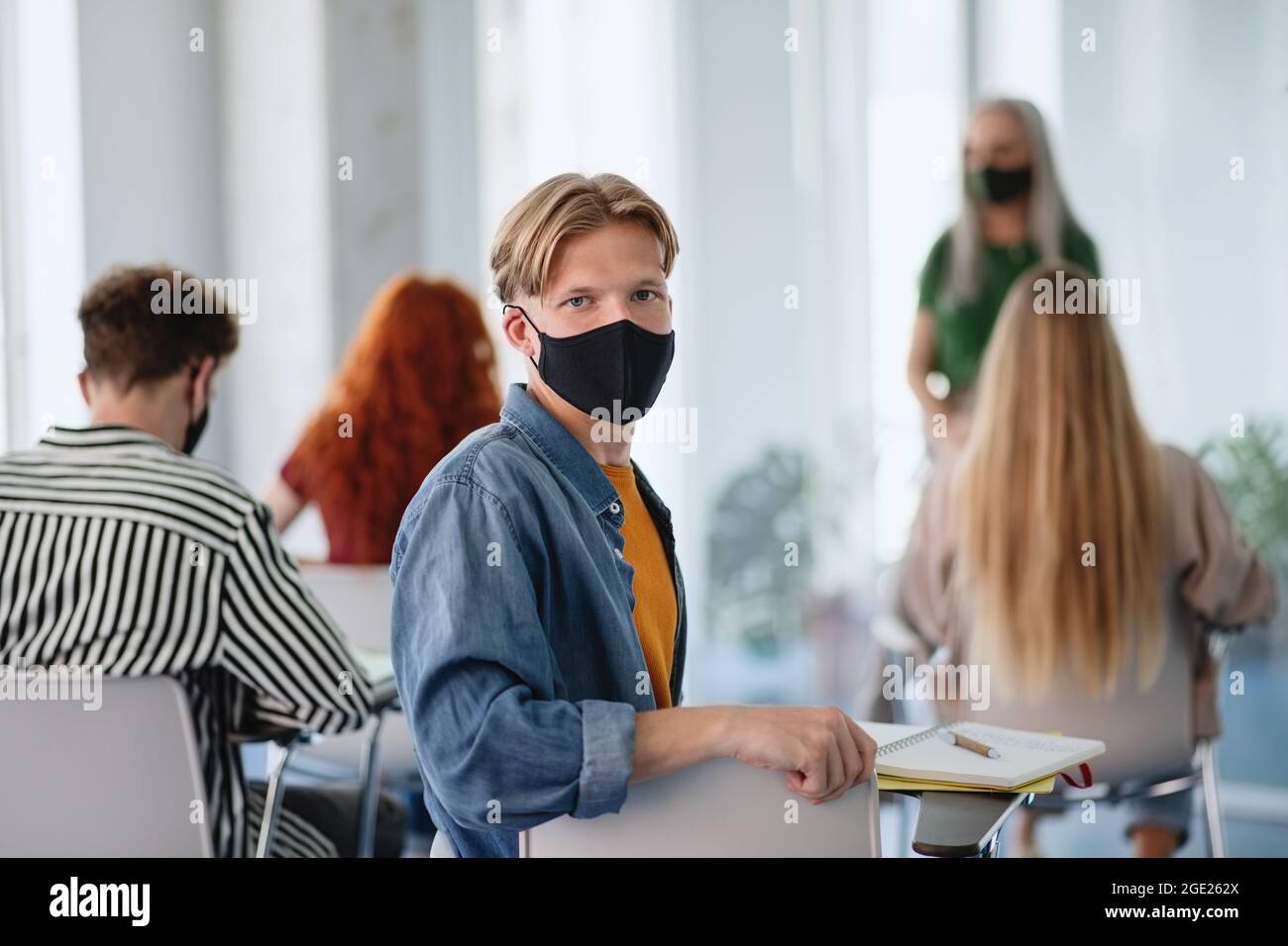 Portrait of university student in classroom indoors, coronavirus and ...