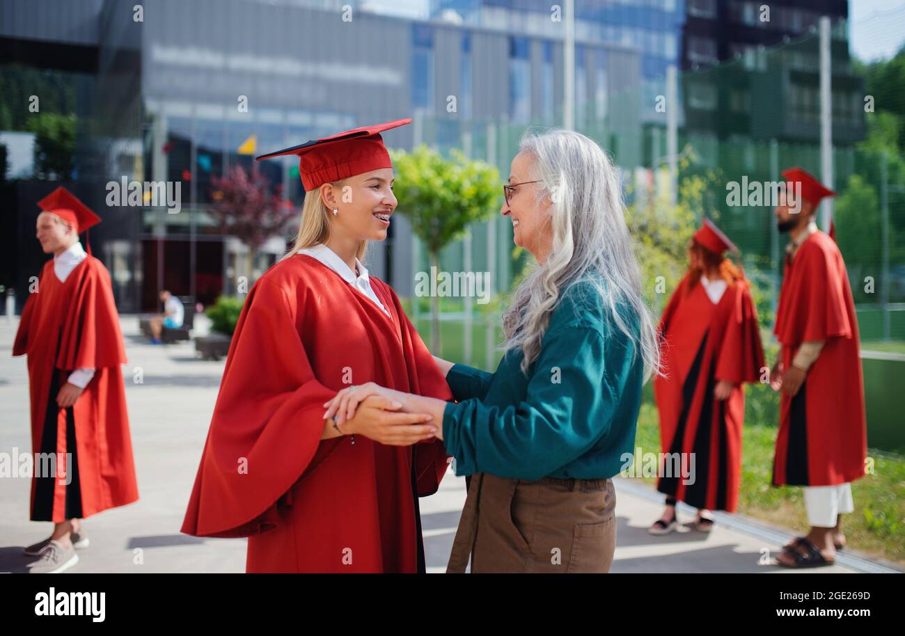 Portrait of cheerful university student with mother celebrating ...