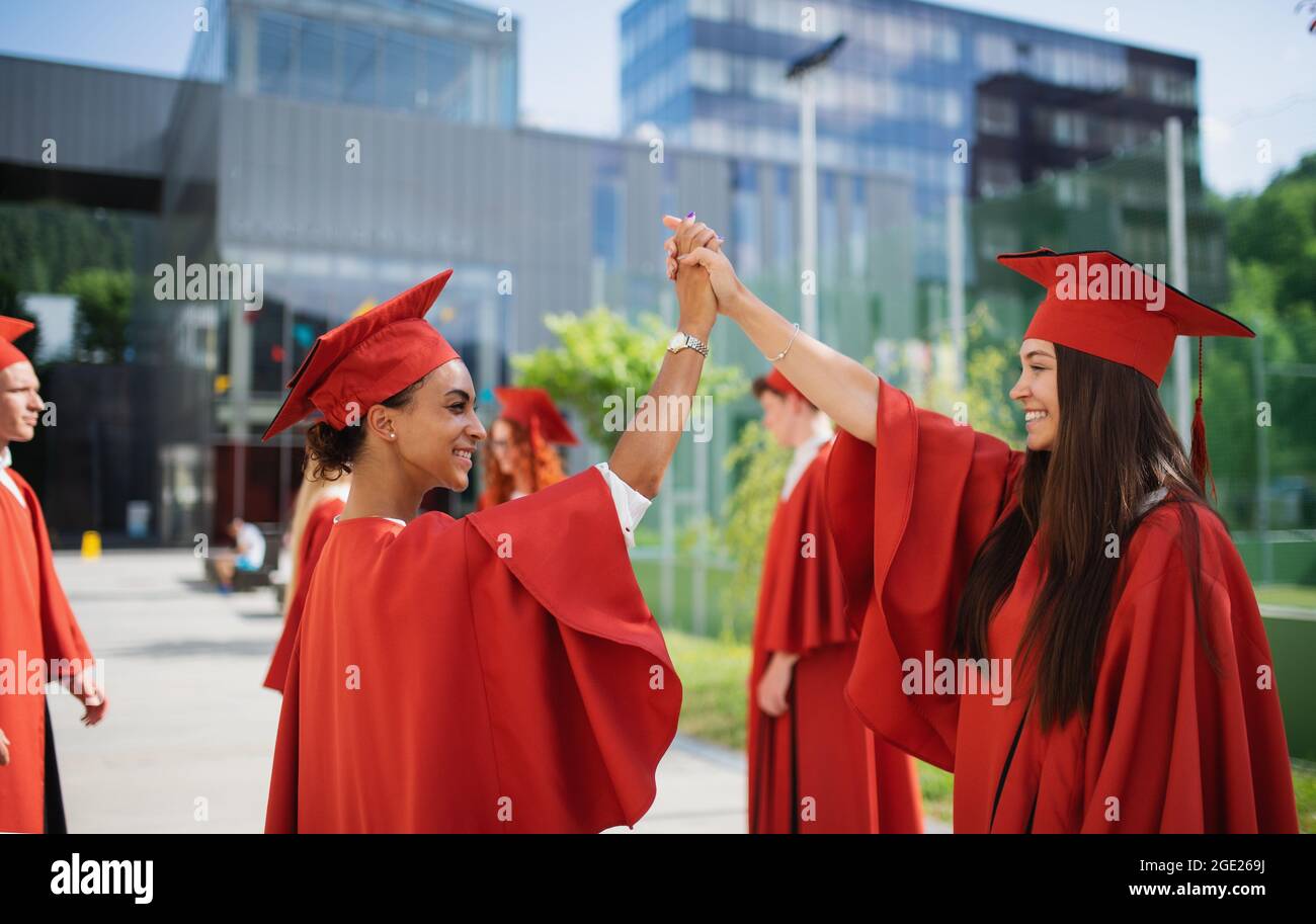 Group of cheerful university students celebrating outdoors, graduation ...