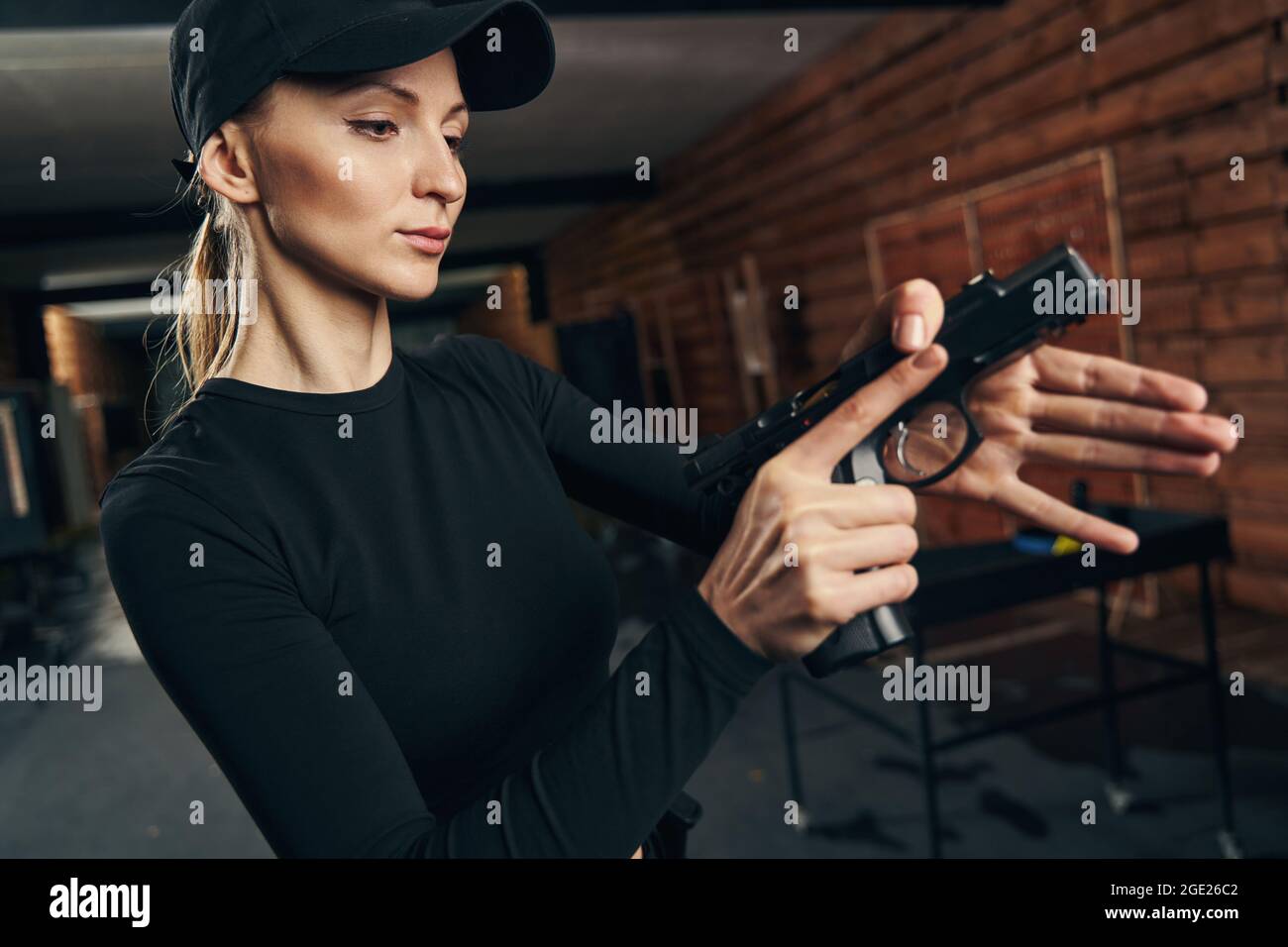 Female concentrated on pulling her gun slide to the rear Stock Photo ...