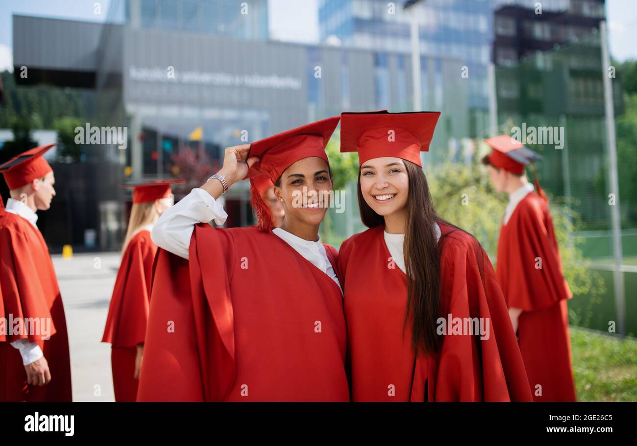 Portrait of cheerful university students celebrating outdoors ...