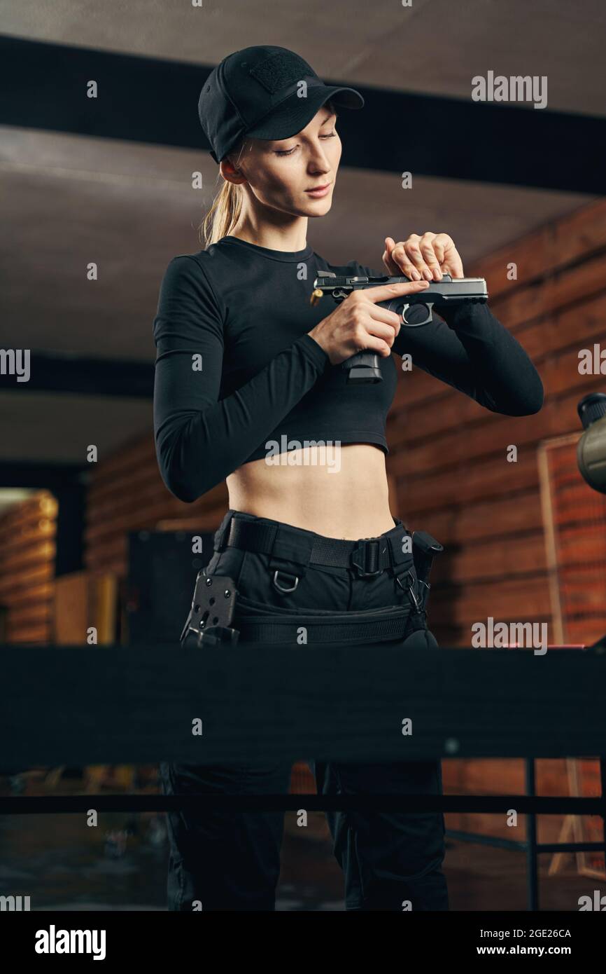 Serious woman focused on reloading her handgun Stock Photo - Alamy