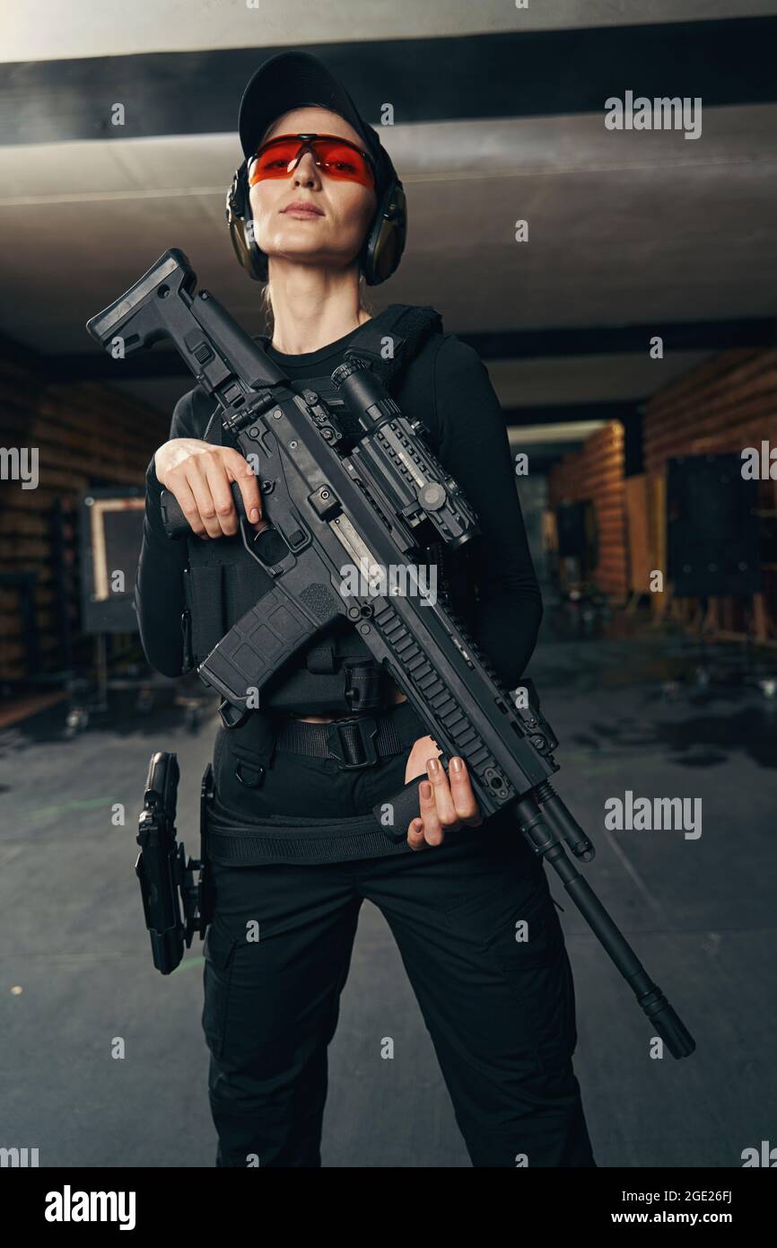 Cute young shooter with a firearm looking ahead Stock Photo - Alamy