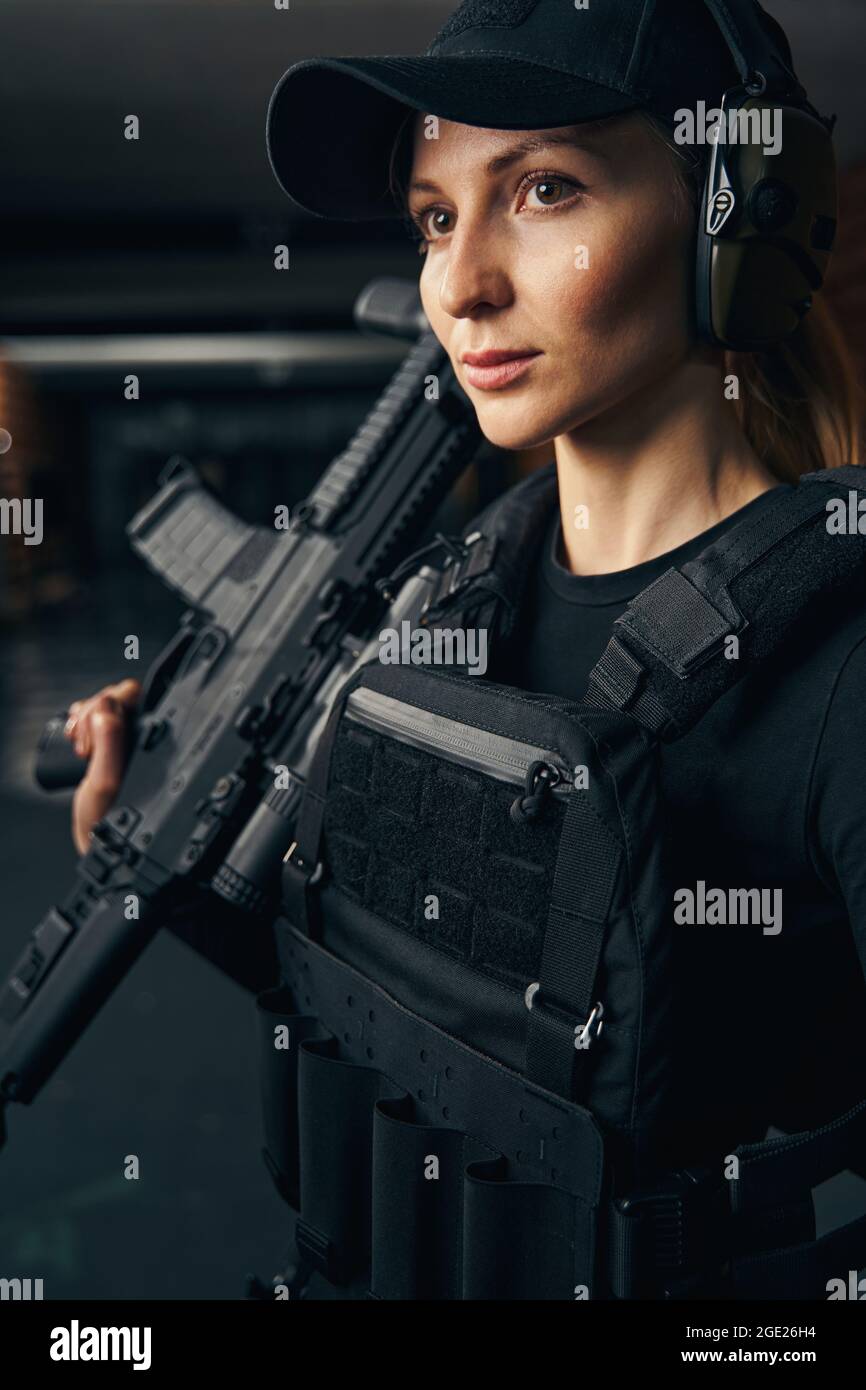 Beautiful female shooter with a firearm over her shoulder Stock Photo ...