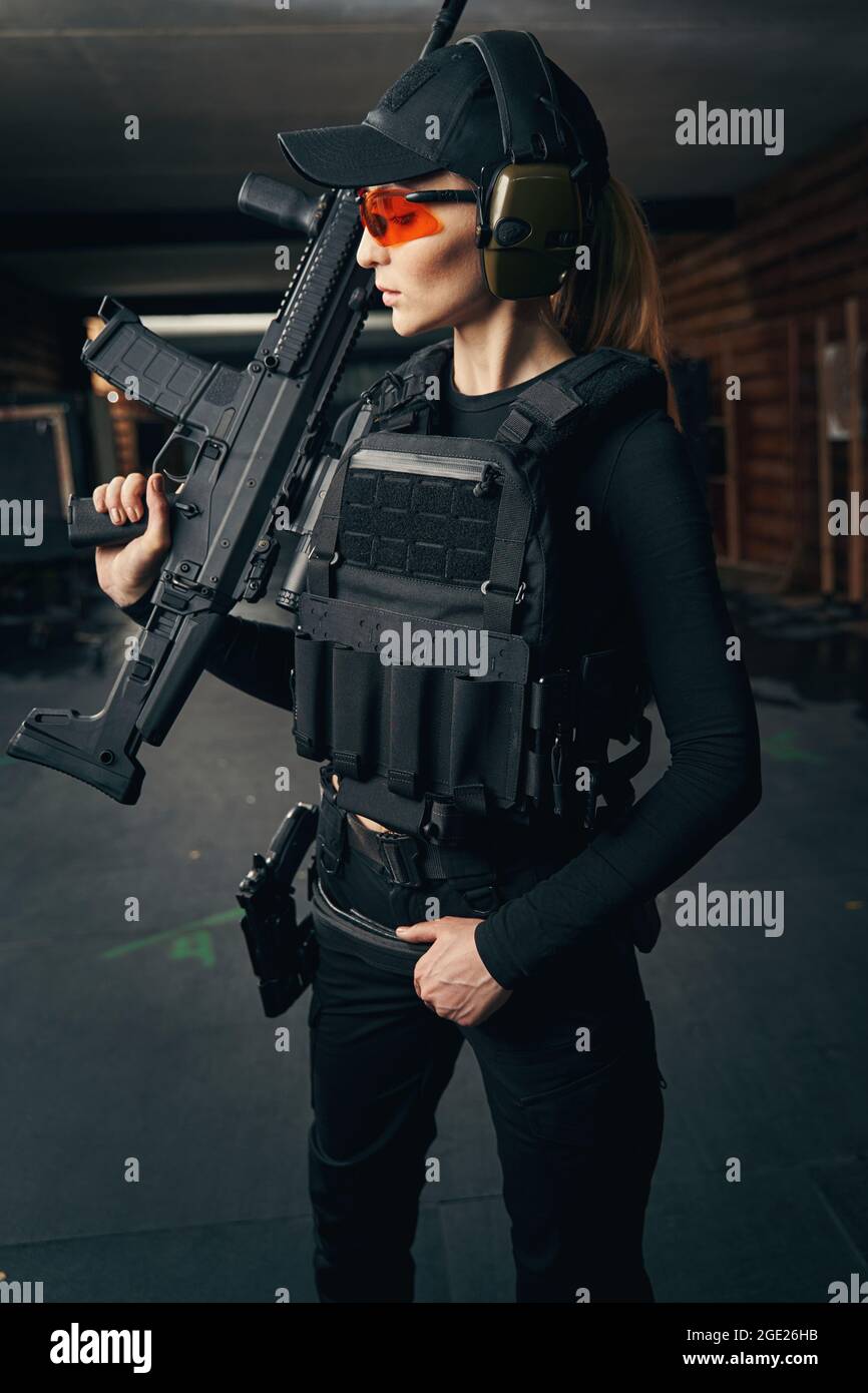 Woman with an assault rifle standing at the shooting range Stock Photo ...