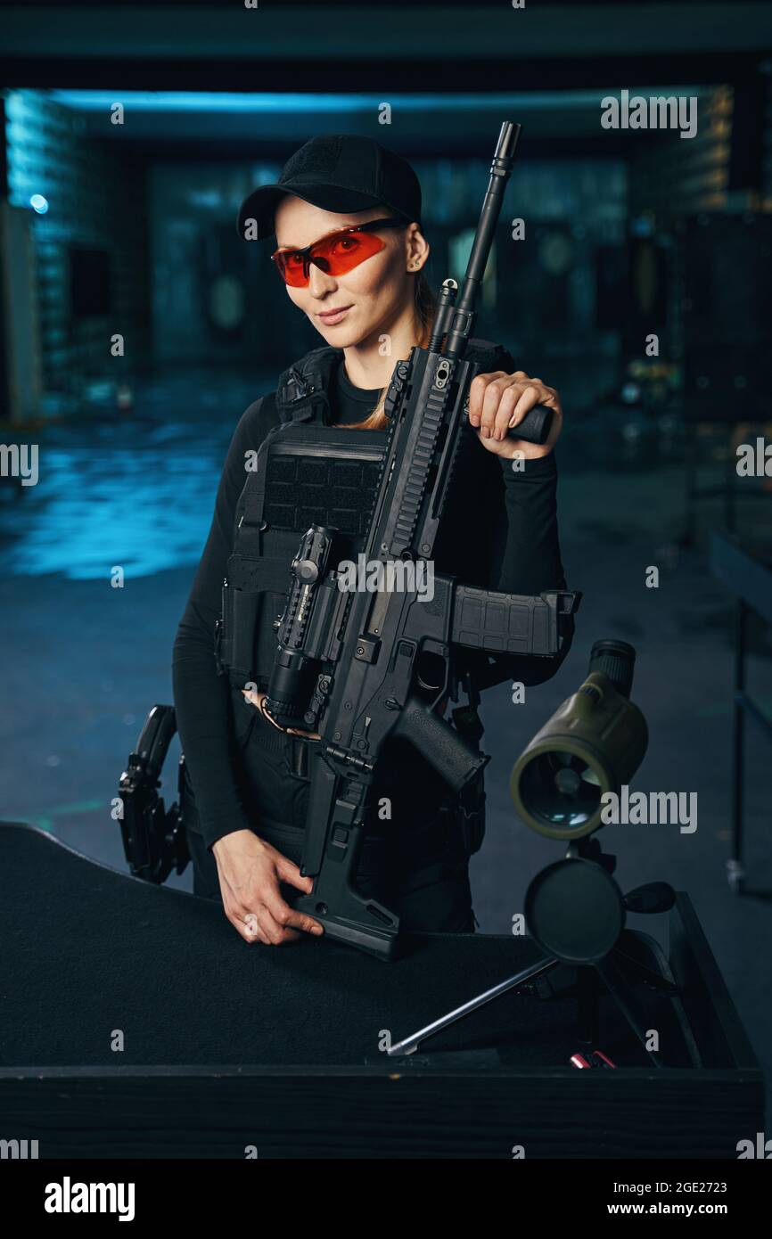 Young woman in a bulletproof vest holding a weapon Stock Photo - Alamy