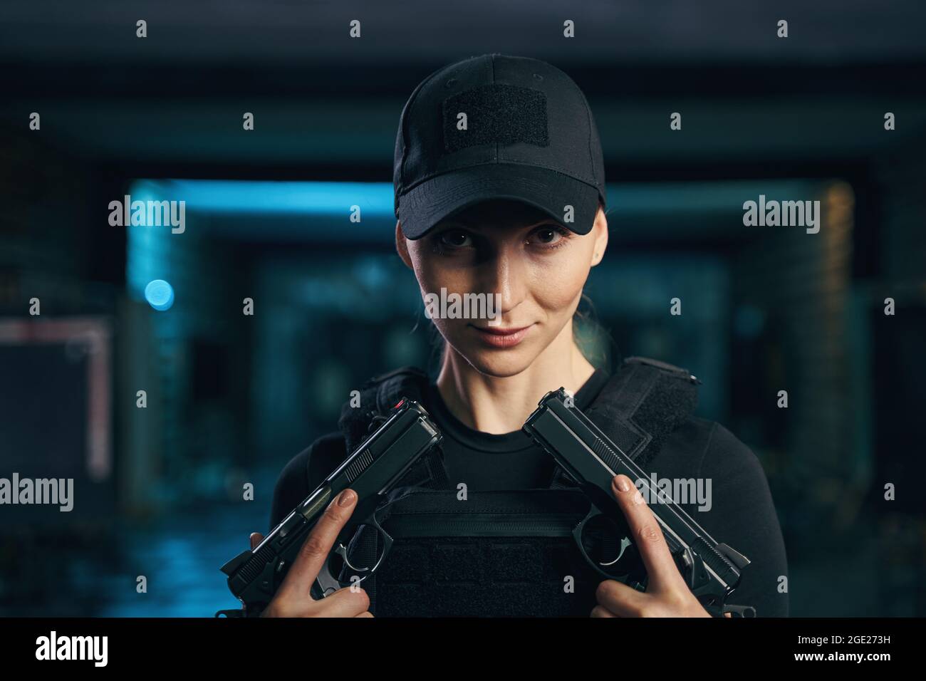 Serene female shooter posing for the camera with two pistols Stock ...