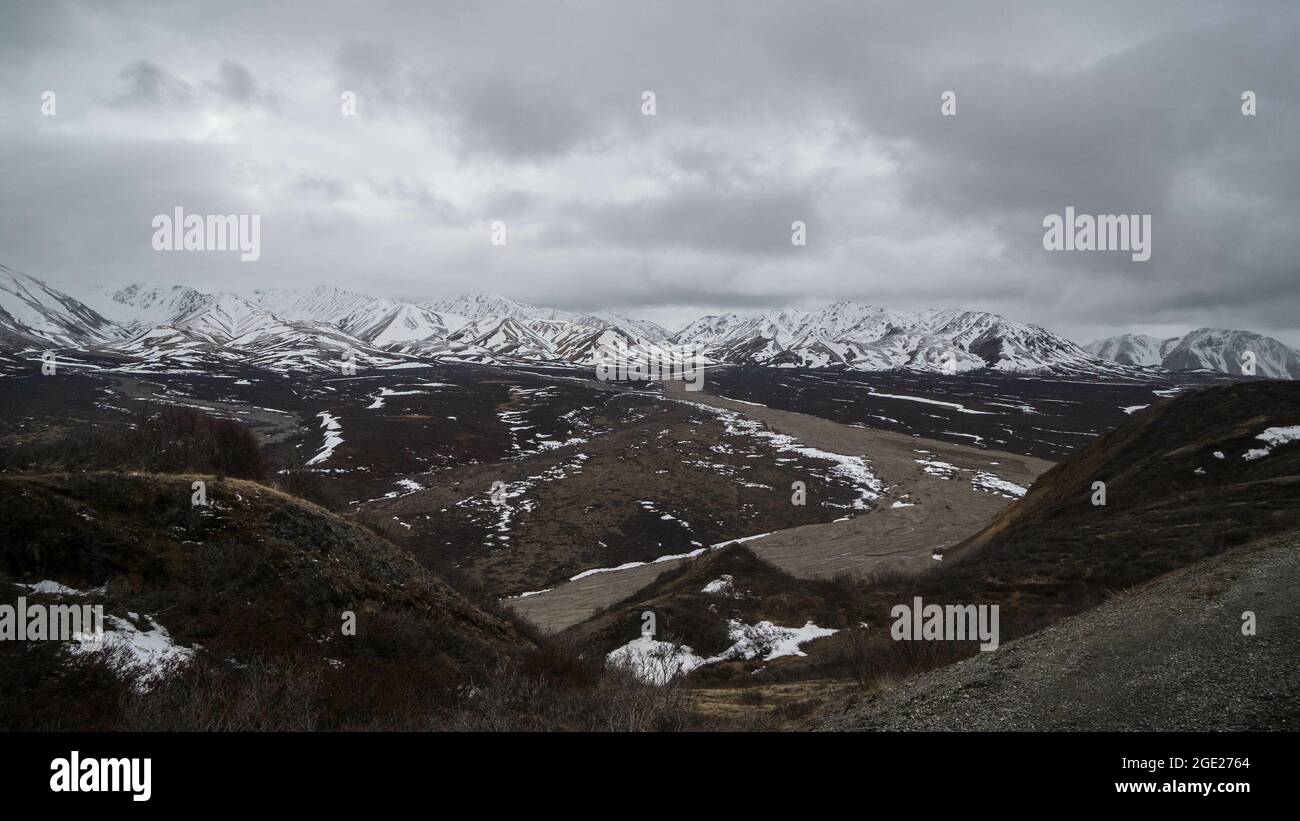 Chilling view of snow-capped mountains under a cloudy sky Stock Photo ...