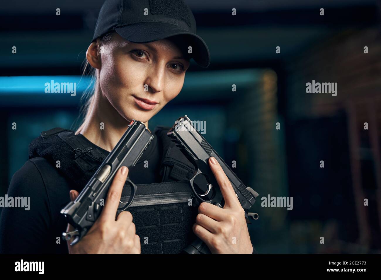 Professional female sniper posing for the camera with her handguns ...