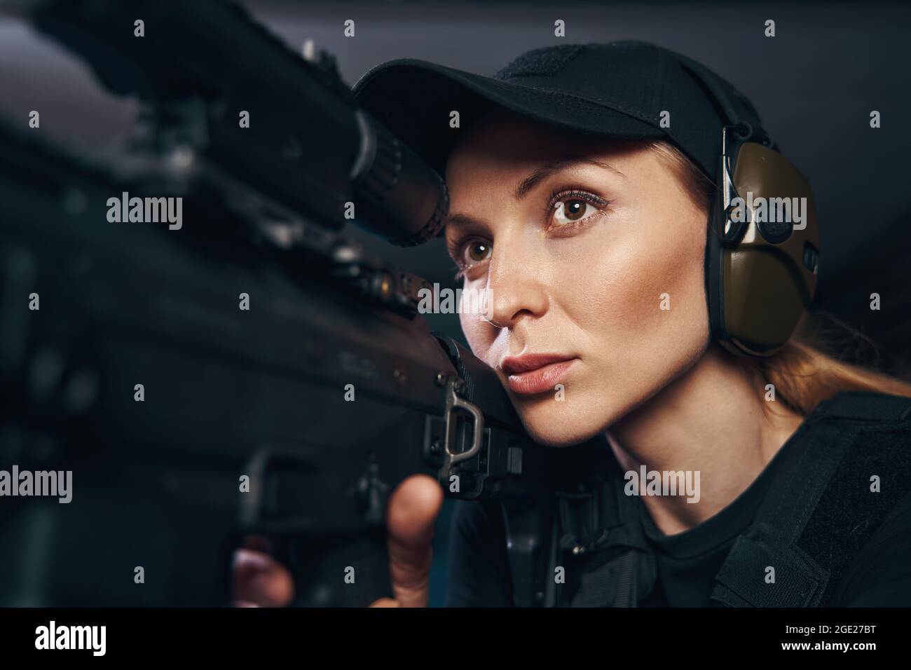 Beautiful concentrated lady firing an assault rifle Stock Photo - Alamy
