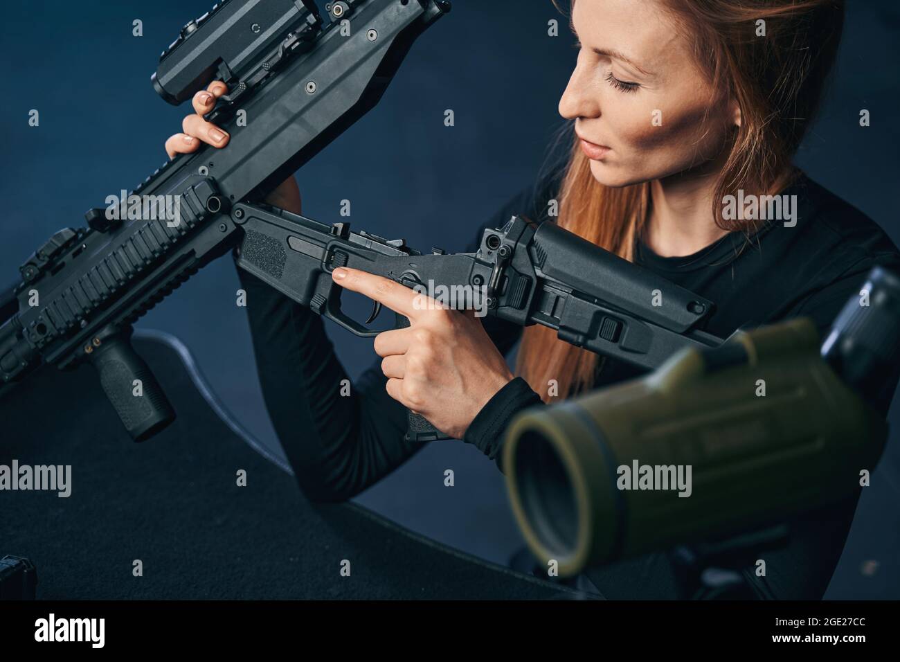 Focused experienced female shooter disassembling a weapon Stock Photo ...