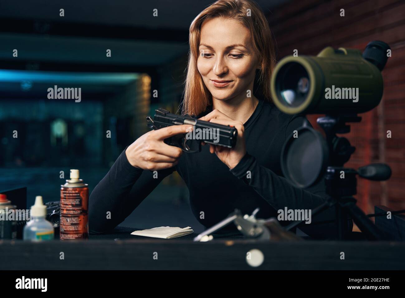 Professional female shooter focused on inspecting her handgun Stock ...