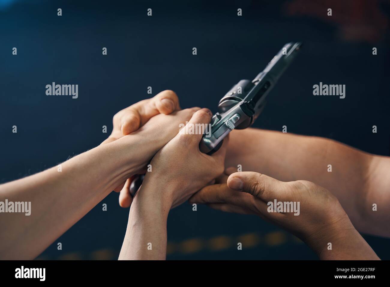 Woman learning to use a revolver assisted by a qualified teacher Stock ...