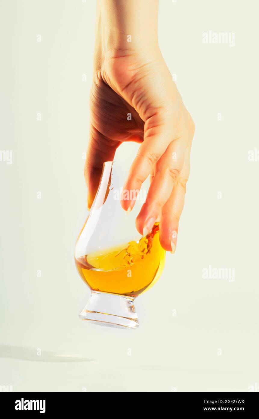 Scotch Whiskey in special glass shaken in hand on white background ...