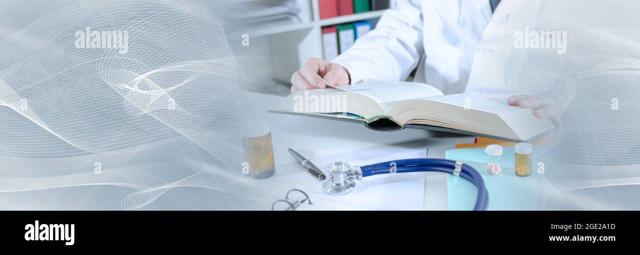 Doctor doing research in a medical book at office; panoramic banner ...