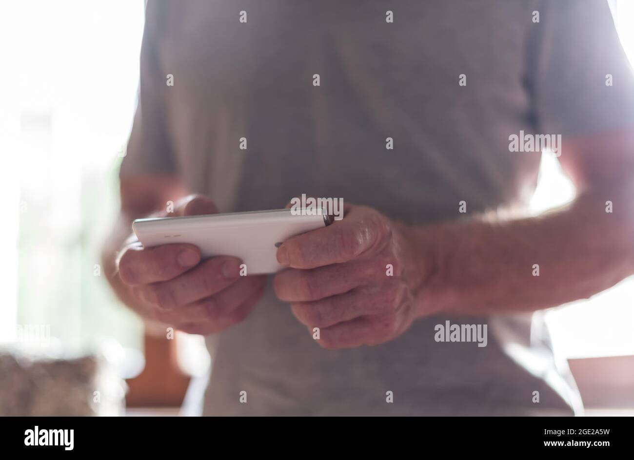 Man standing using his smartphone Stock Photo - Alamy