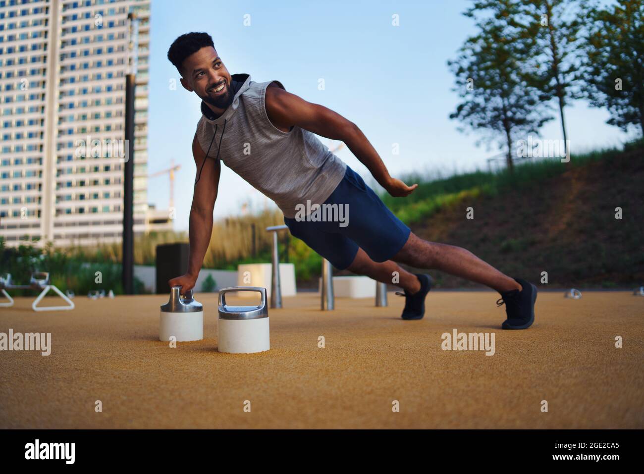 Man doing workout exercise outdoors in city, push up on one hand Stock ...