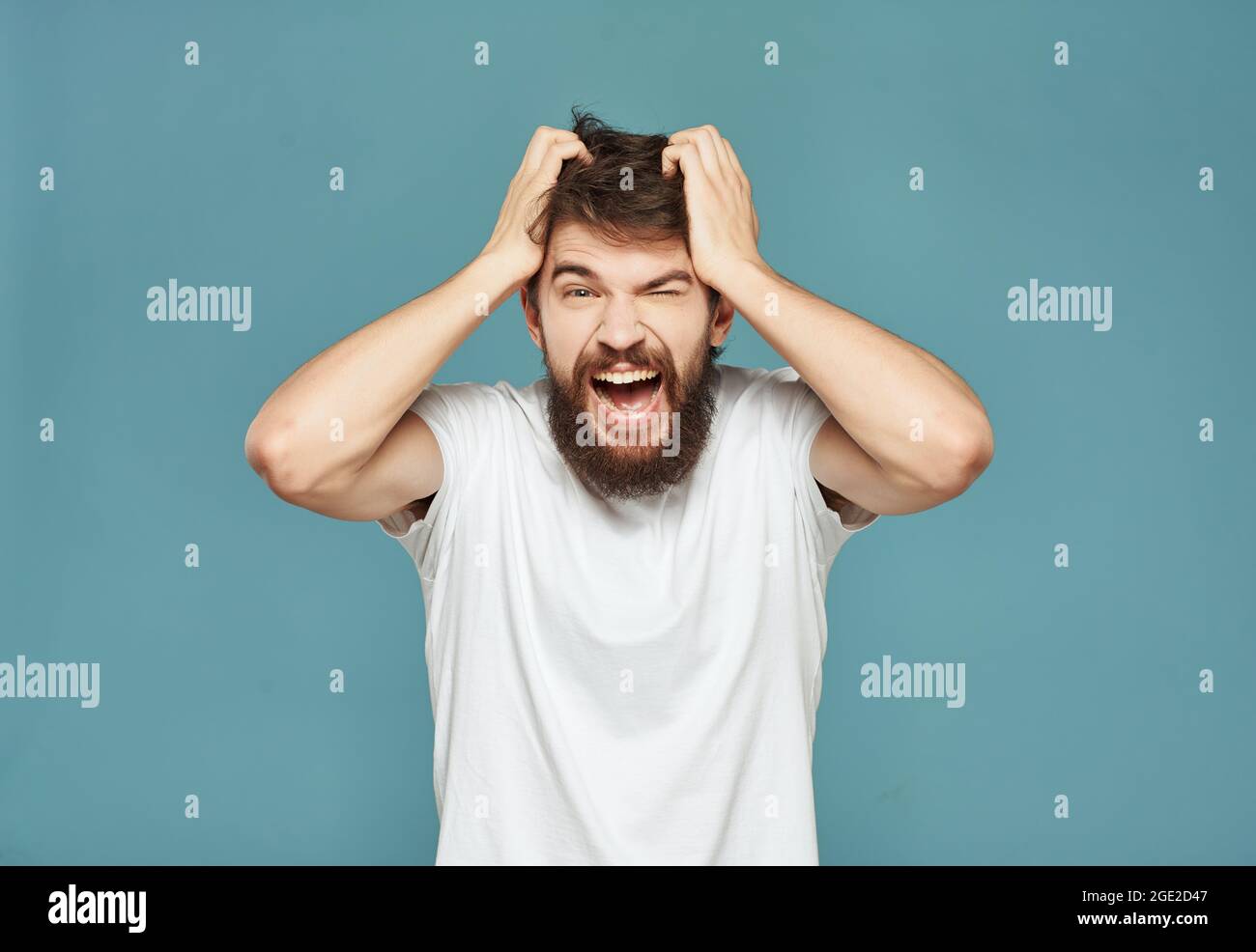 emotional man in a white t-shirt hand gestures anger blue background ...