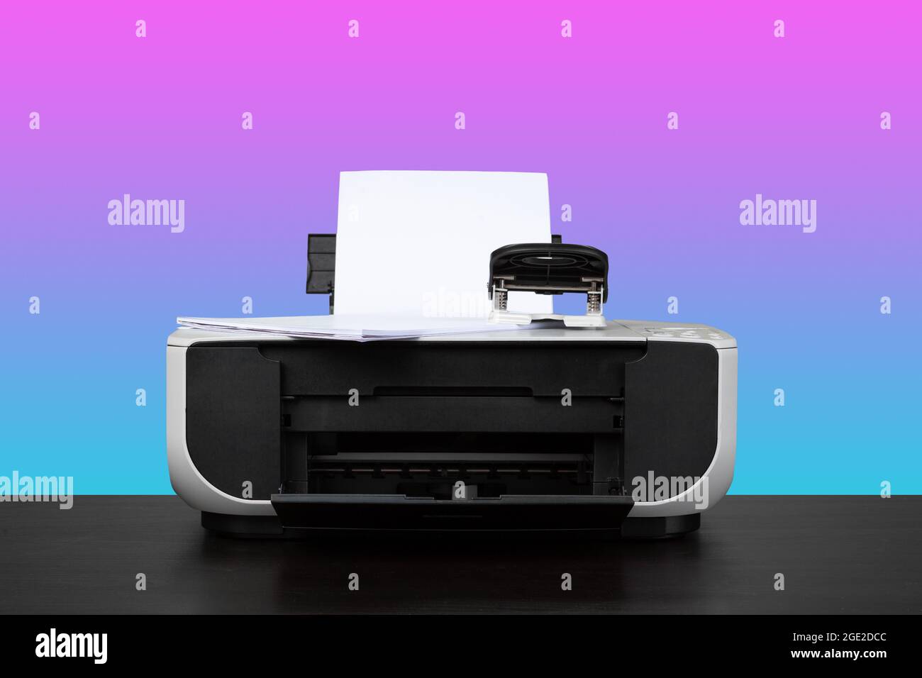 Home laser printer on desk against purple background Stock Photo - Alamy