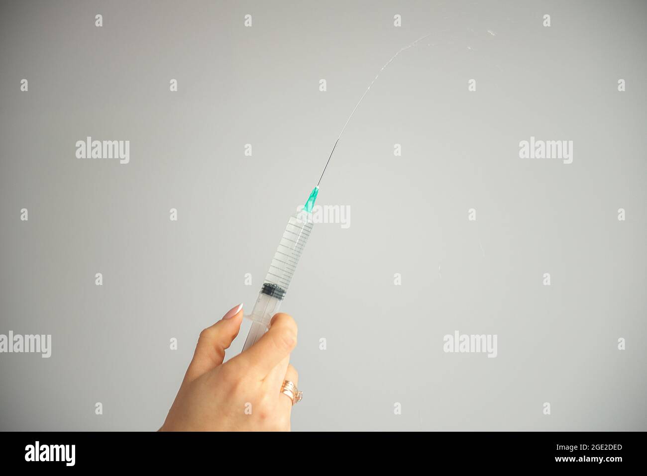 Syringe, medical injection in hand, palm or fingers isolated on gray ...