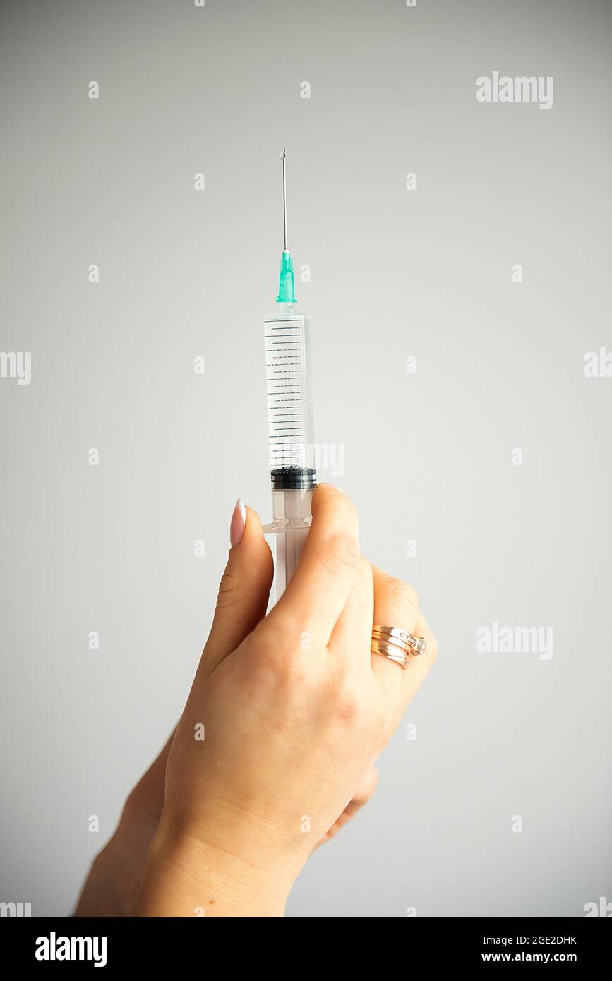 Syringe, medical injection in hand, palm or fingers isolated on gray ...