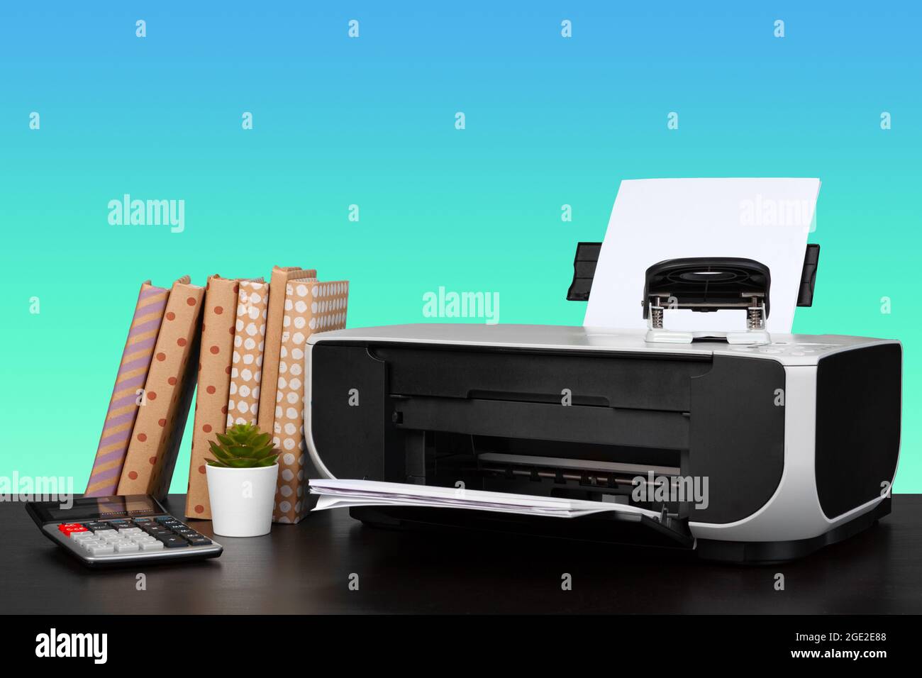 Home laser printer on desk against green background Stock Photo - Alamy